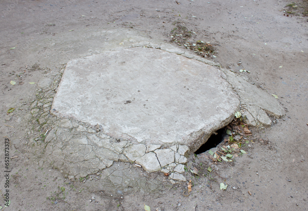 Photo of an old broken sewer manhole with a concrete cover. Old ...