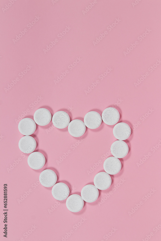 Effervescent tablets in the shape of a heart on a pink background Stock ...