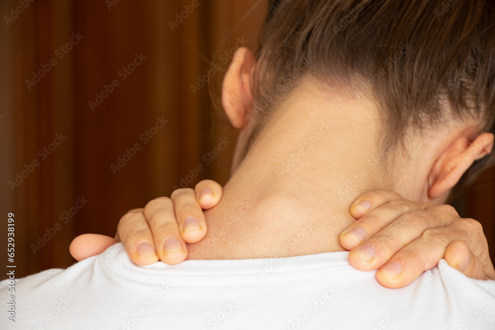 A girl holds her hands behind her neck , sore neck, acute pain in the ...