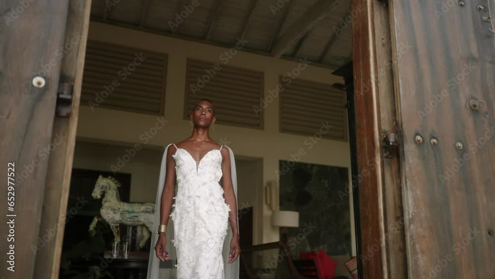 Elegant androgynous person of color walks model gait around villa and ...