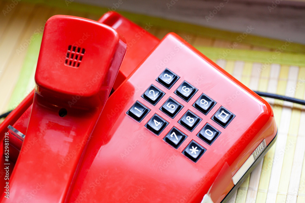 Old retro style red landline telephone with black number buttons object ...