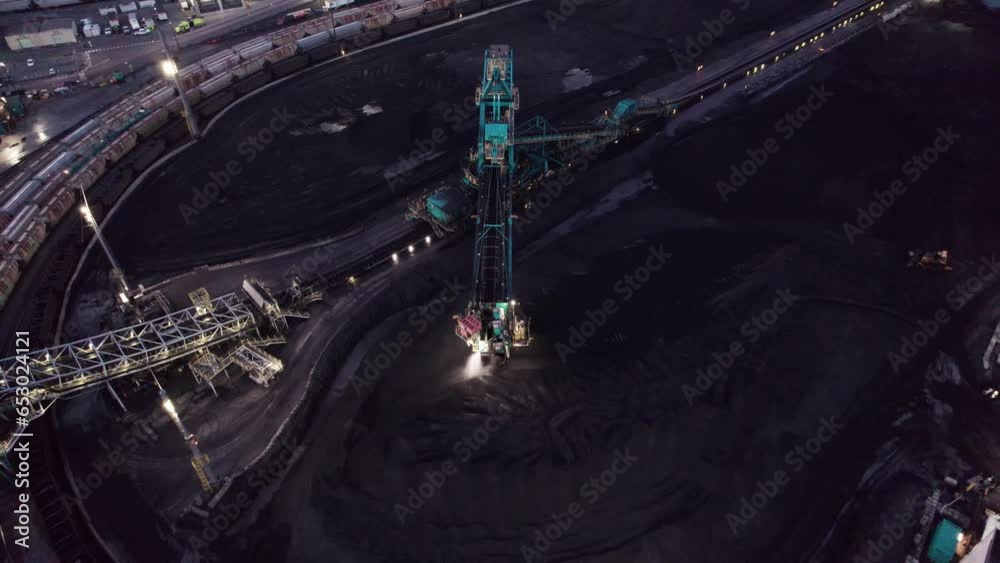 Rotary shovel at coal pile loading freight vessels at bulk shipping ...