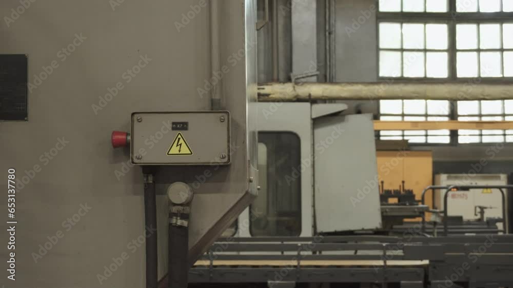 Electrical distribution board with high voltage sign and red emergency ...
