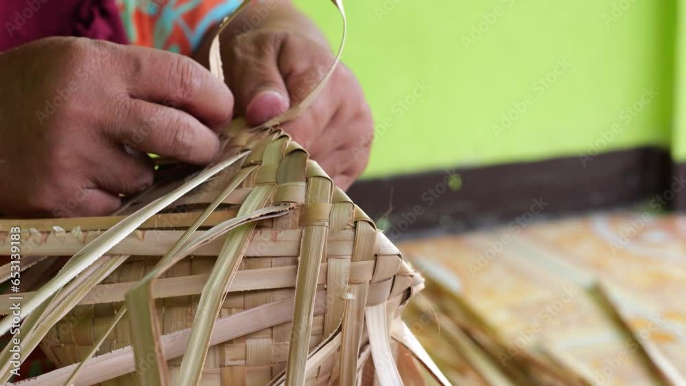 An Indonesian woman´s hand weaving an ancestral basket case from ...