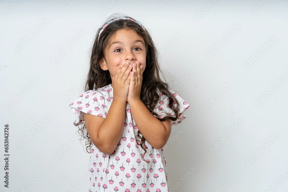 Vivacious beautiful kid girl wearing dress , giggles joyfully, covers ...