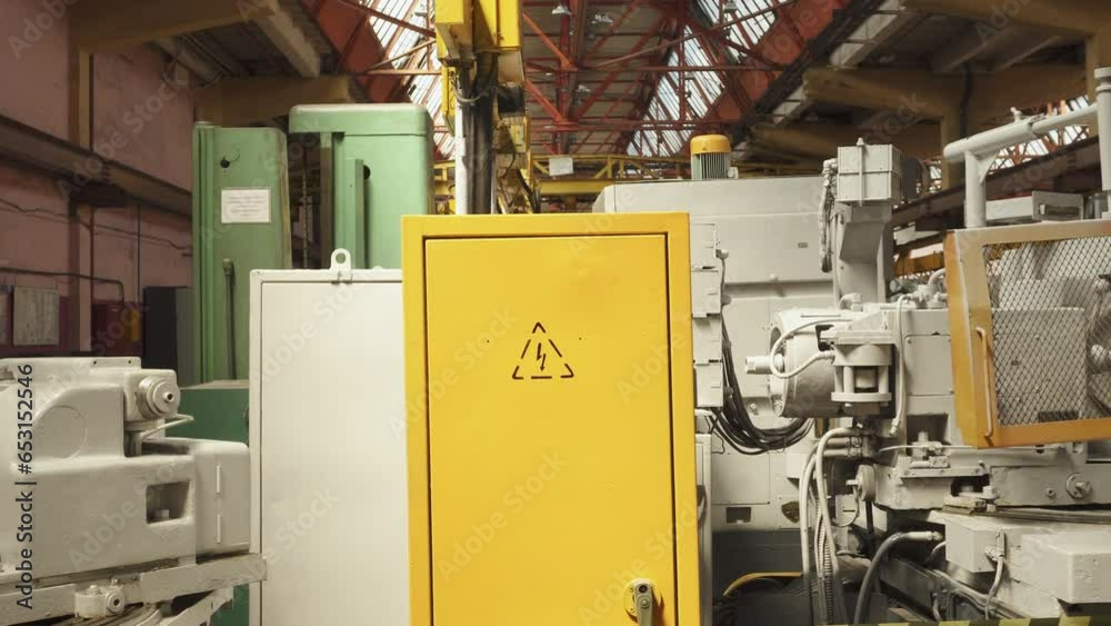 Yellow metal cabinet with high voltage danger sign next to machine ...