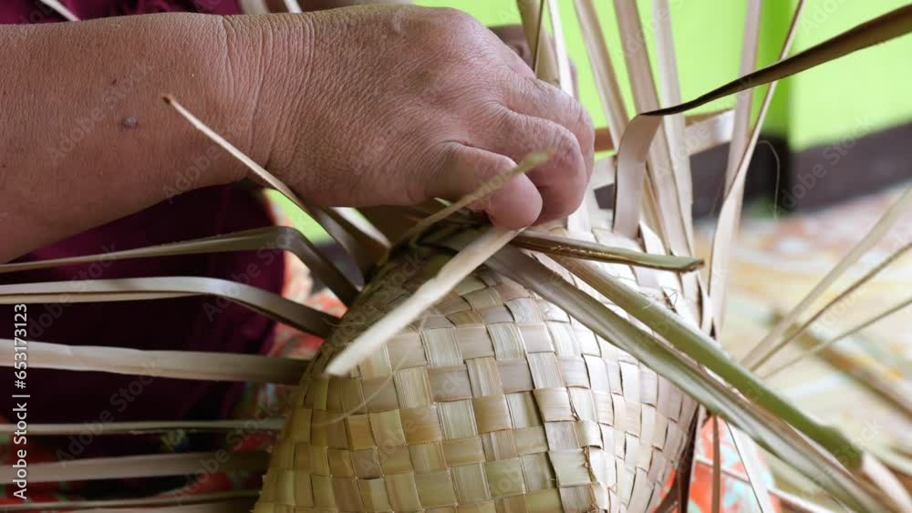 An Indonesian woman´s hand weaving an ancestral basket case from ...