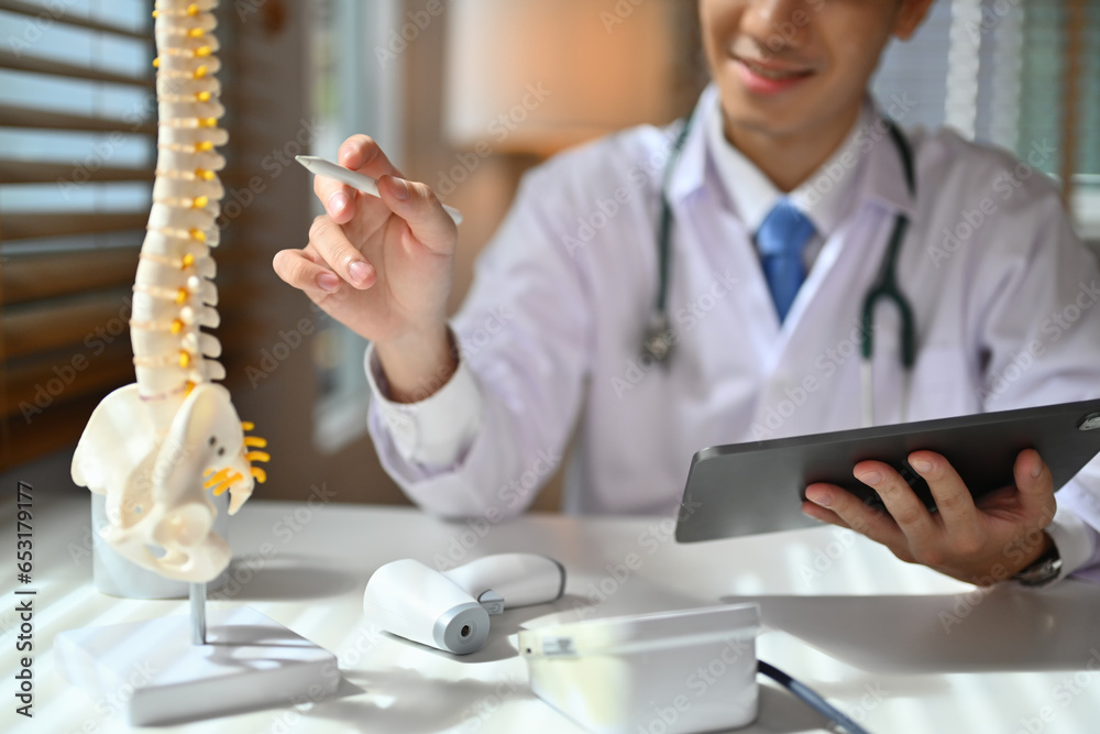 Orthopedists holding digital tablet and pointing at model. Concept of ...