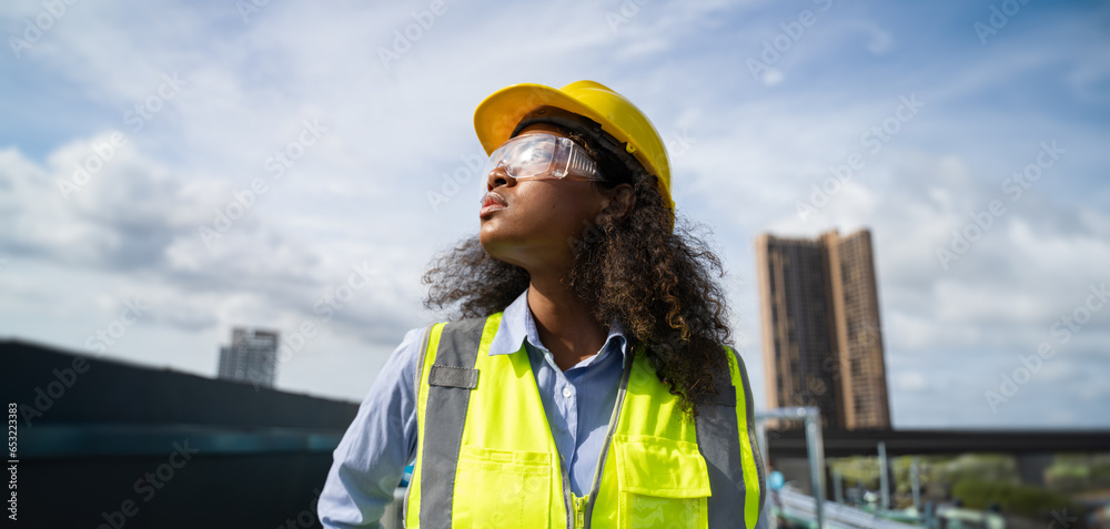 Civil engineer woman dark skin wearing uniform and safety helmet under ...
