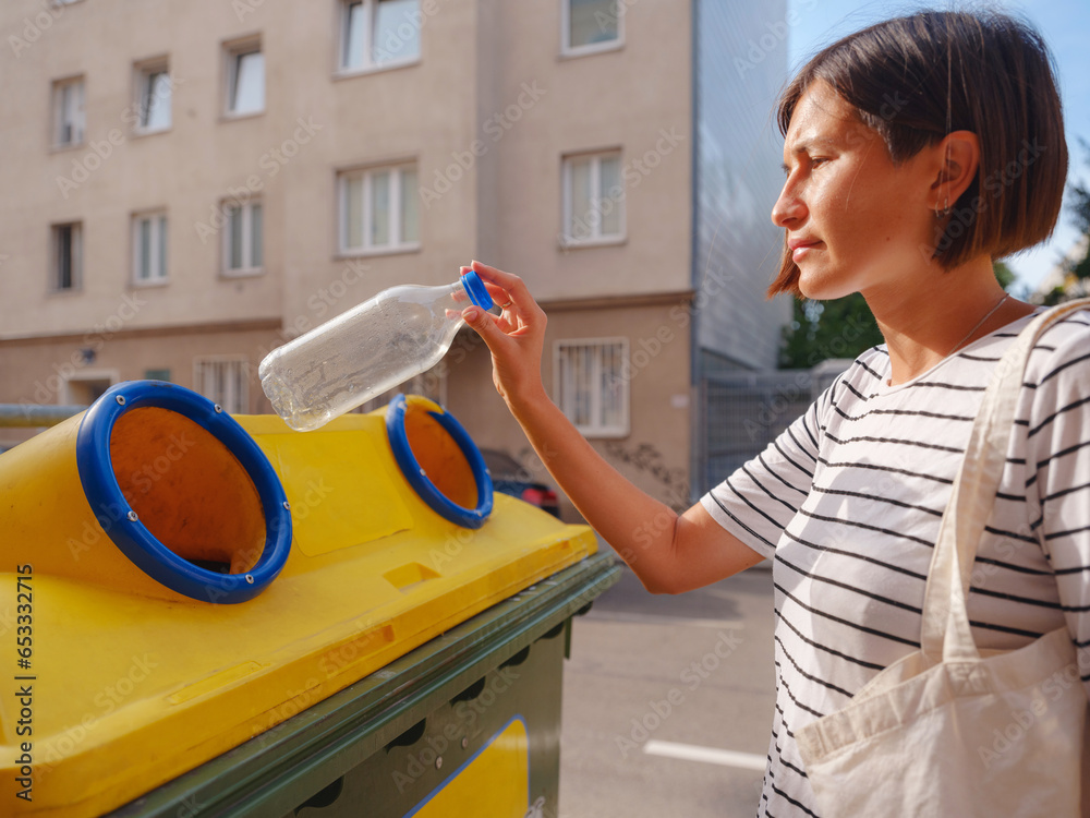 woman throwing plastic bottle Recycling bin stand on european street ...