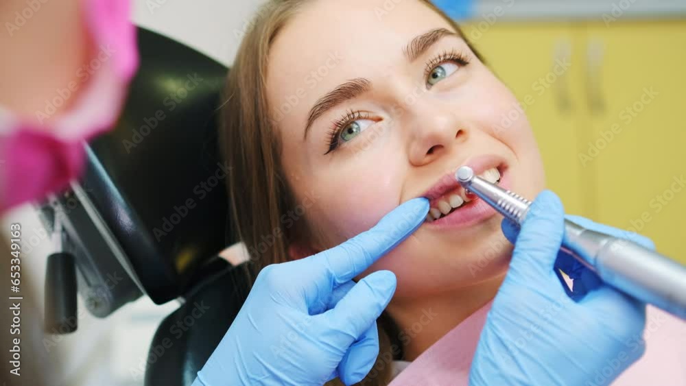 Dentist performing teeth grinding procedure in dental clinic. Woman ...
