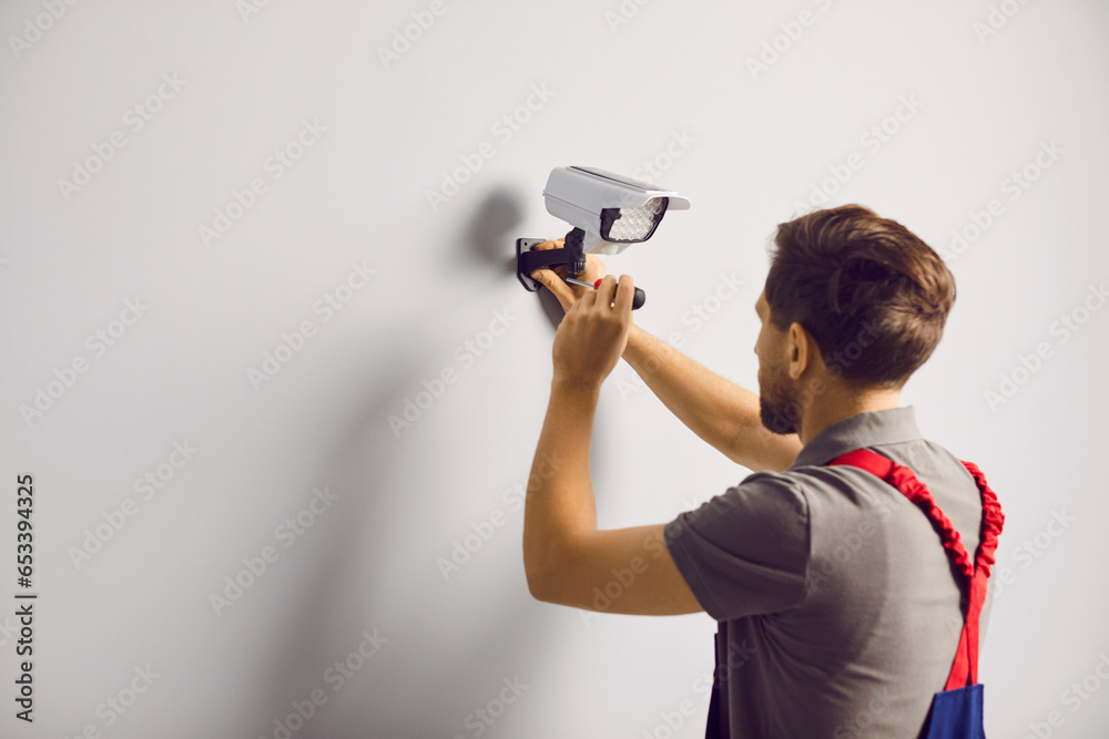 Portrait of a young technician man standing back installing ...