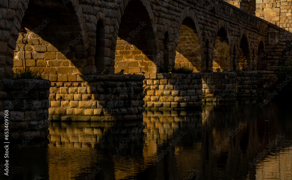 Six rock brick arches of Mérida's Roman bridge over the Guadiana River ...