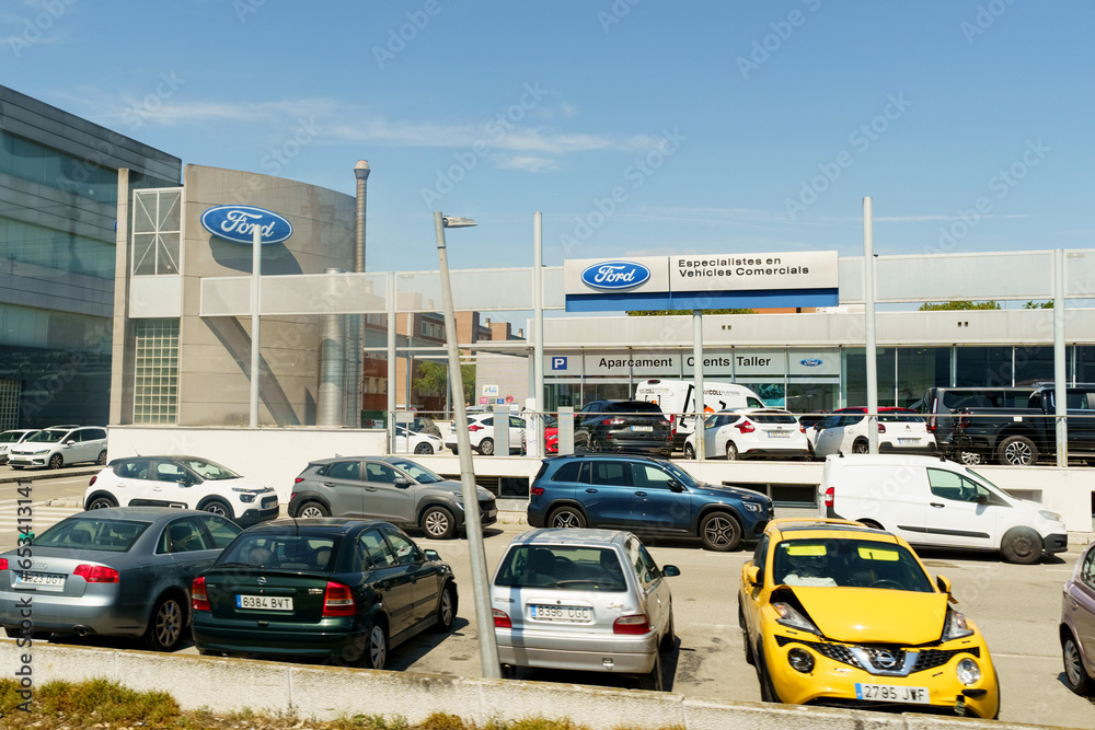 Ford car dealership against a blue sky, next to a parking lot with cars ...