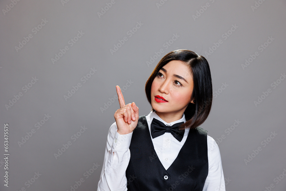Catering service asian waitress pointing upwards with finger and ...