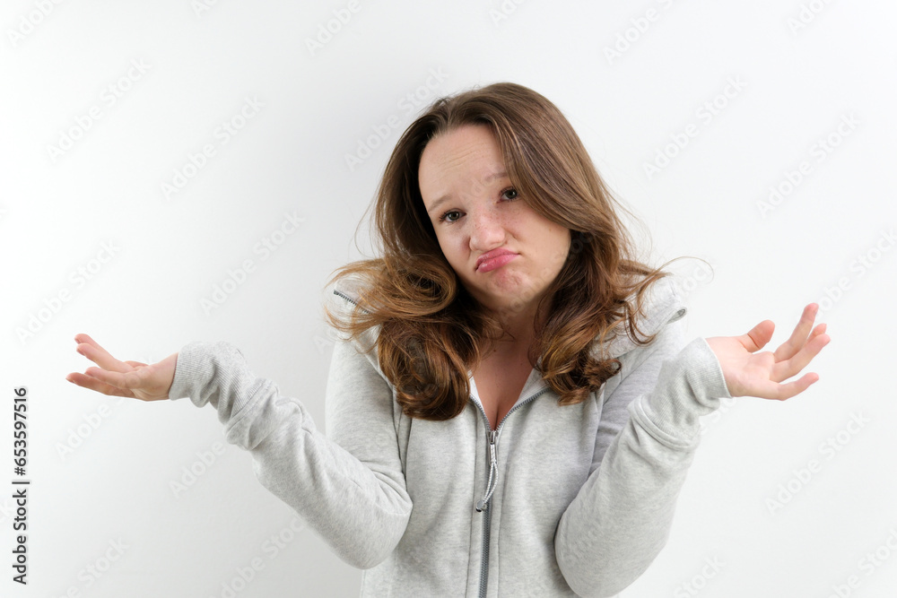 Puzzled young caucasian woman looks uncertain and confused. shrug ...