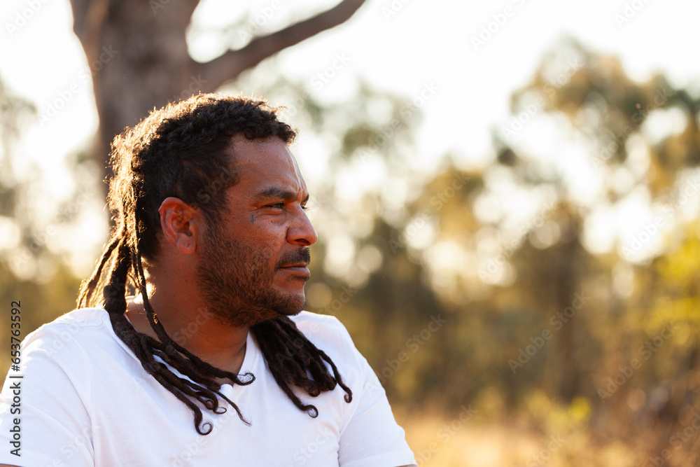 Side profile portrait of aboriginal man looking away with dreadlocks ...