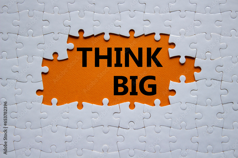 Think big symbol. White puzzle with words Think big. Beautiful orange ...