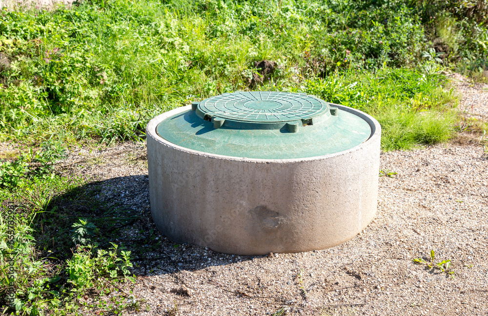 Covered sewer manhole of rural septic tank with green plastic cover ...