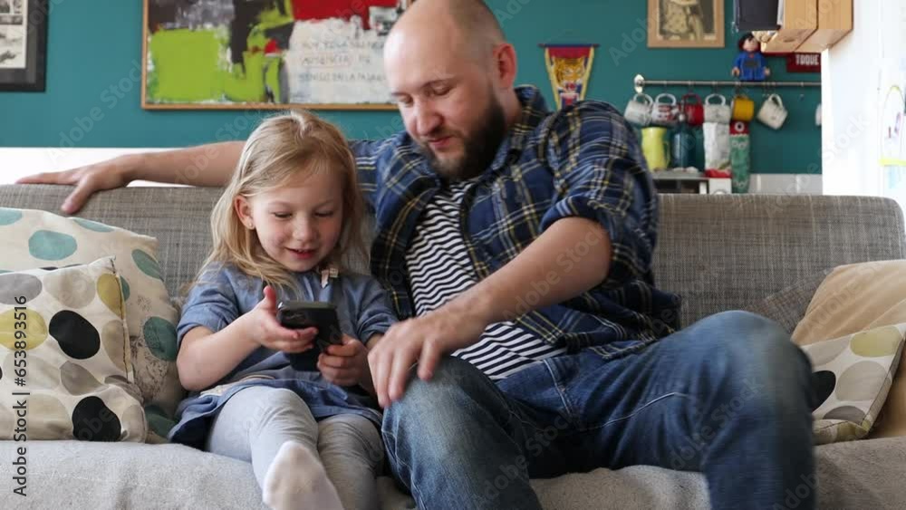 Dad shows his daughter on the phone photos and videos. Stock Video ...