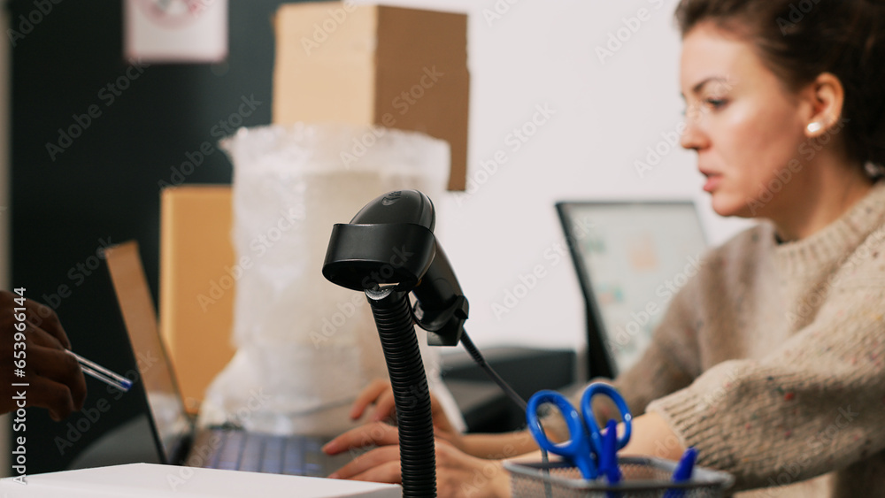 Two employees packing goods in boxes, preparing orders for retail store ...