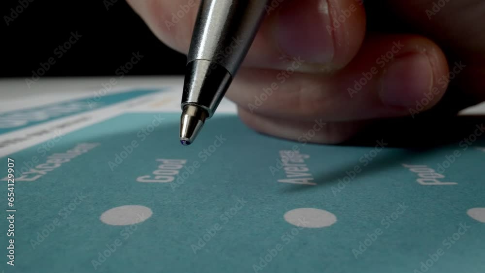 Closeup macro shot movement hand filling feedback survey form with pen ...
