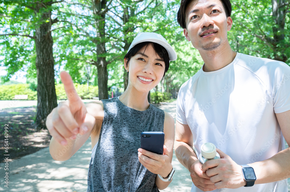 Asian man and woman doing fist bumps in the beautiful morning park ...