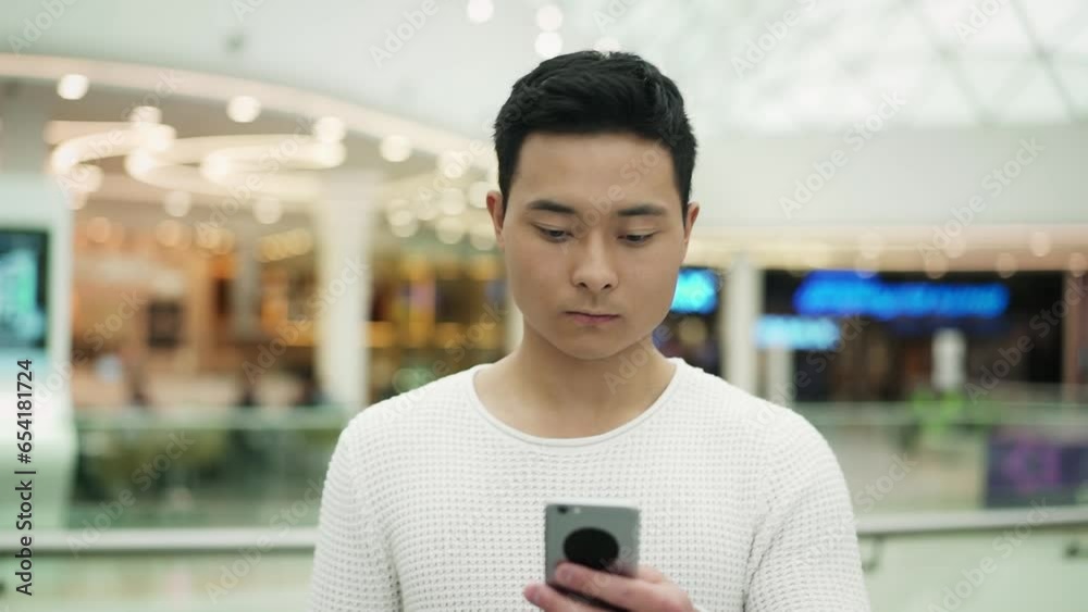 Tracking portrait shot of handsome asian man wearing white sweatshirt ...