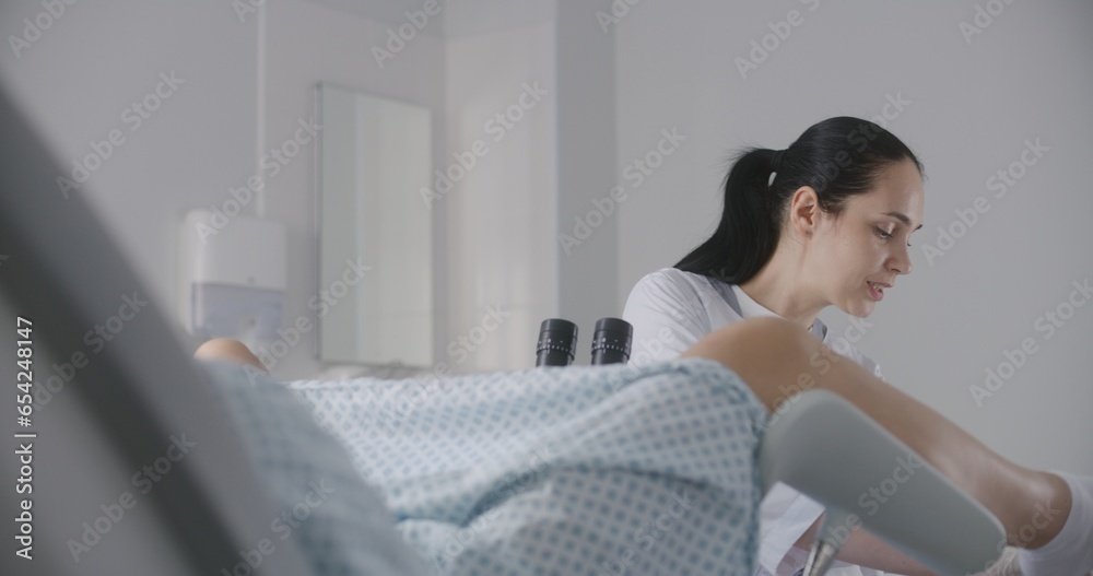 Gynecology room in hospital. Female gynecologist uses colposcope, takes ...