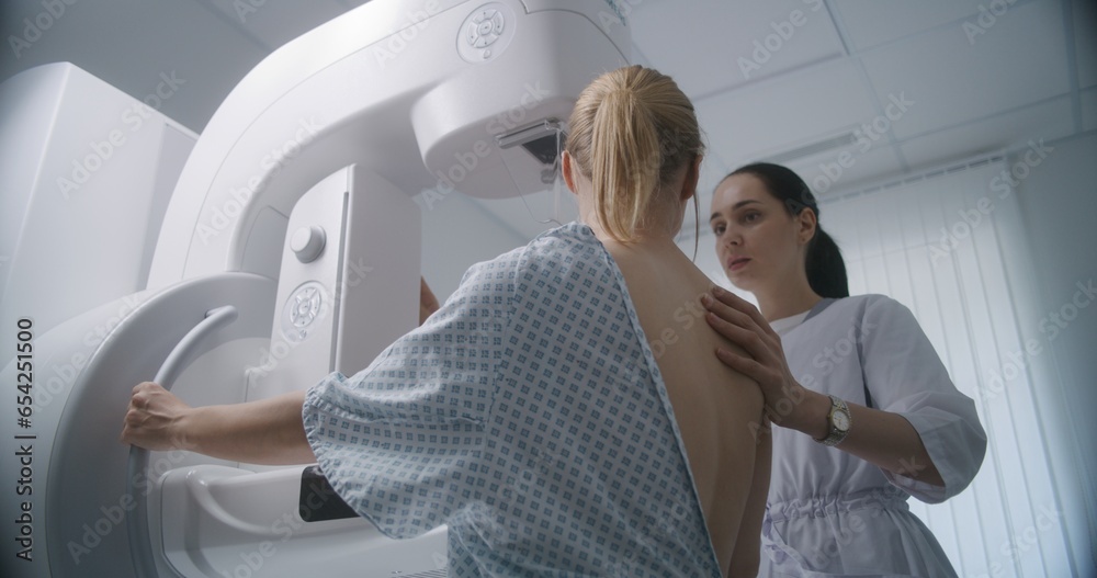Hospital radiology room. Caucasian woman stands during mammography ...