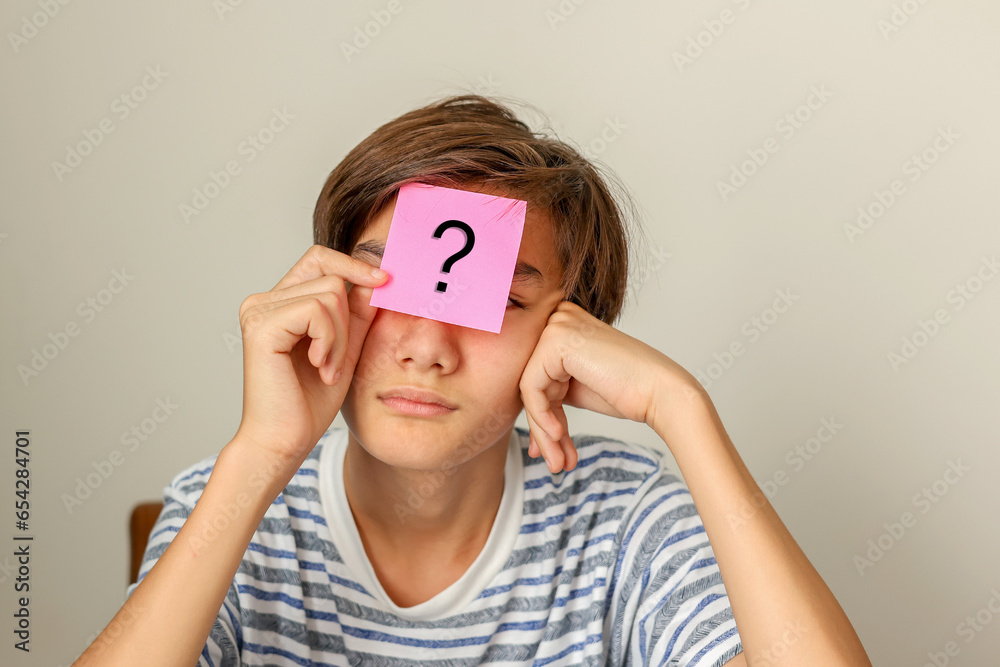 Thinking teenager boy, school student with question mark on paper on ...
