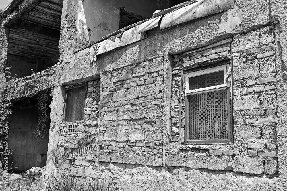 Old half-collapsed house with brick wall, facade with window and large ...