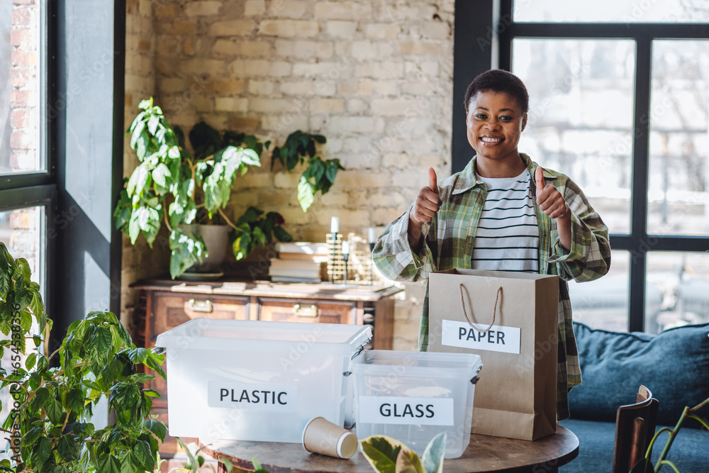 Young university student is managing waste sorting at home, smiling ...