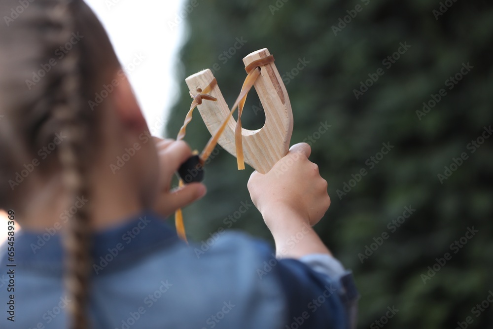 Little girl playing with slingshot outdoors, closeup Stock Photo ...