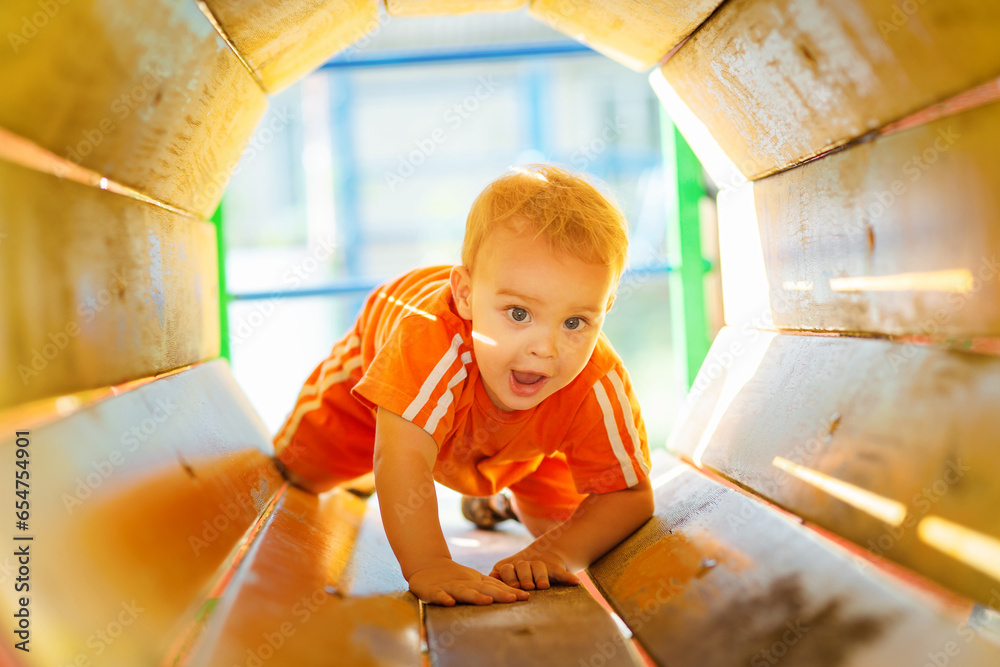 Cute little boy walking on playground in park, child creers through the ...