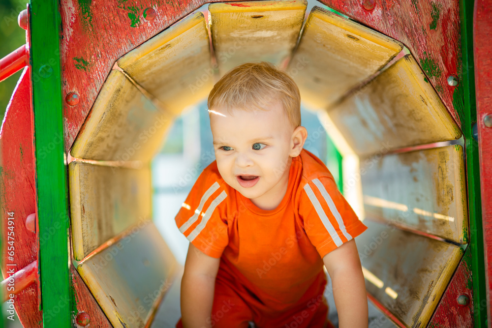 Cute little boy walking on playground in park, child creers through the ...