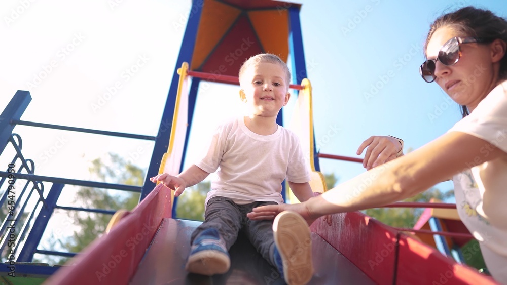 child slides down the slide on the playground. happy family kid dream ...