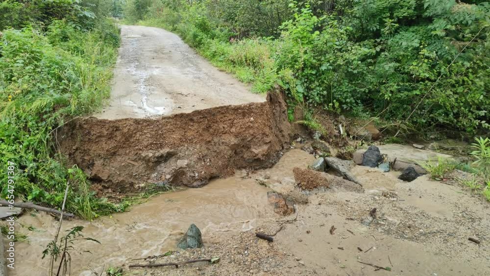 Flood washed away country road. Streams of water sweep away everything ...