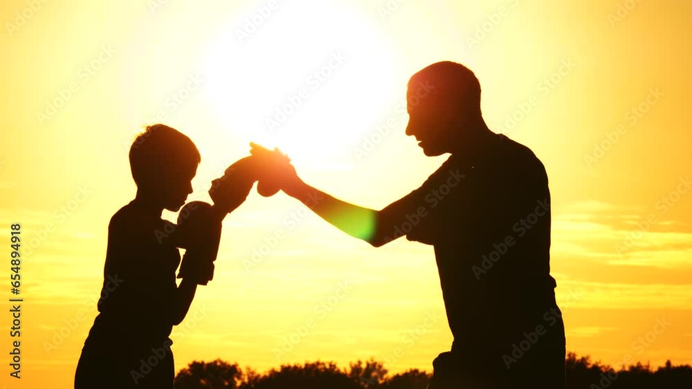 Video Stock Silhouette of a man and a child. A coach teaches a child ...