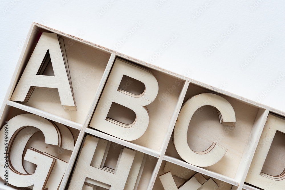 shallow wooden box with square compartments and wooden letters with ...