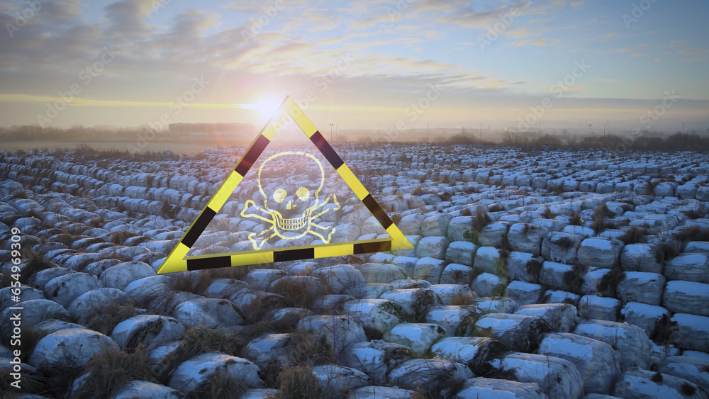 Biohazard hazard warning symbol with a danger skull over a garbage dump ...