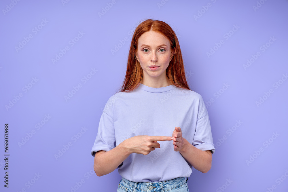 Studio photo of young ginger lady keeping forefinger on raised palm ...
