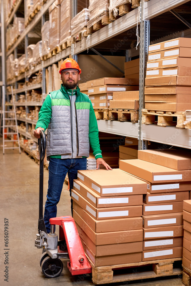 caucasian warehouse worker with manual pallet jack, working in storage ...