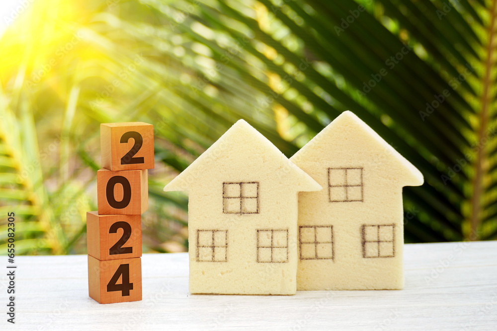 Miniature houses and wooden blocks number 2024 are used as concepts for ...