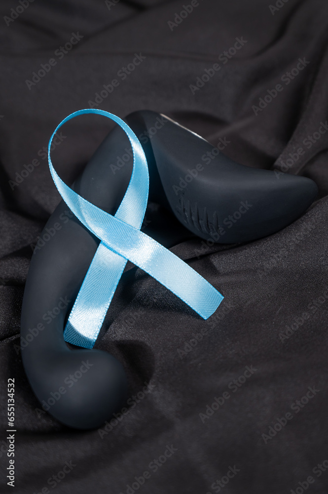 Prostate stimulator and blue ribbon on a black silk sheet. Symbol of ...