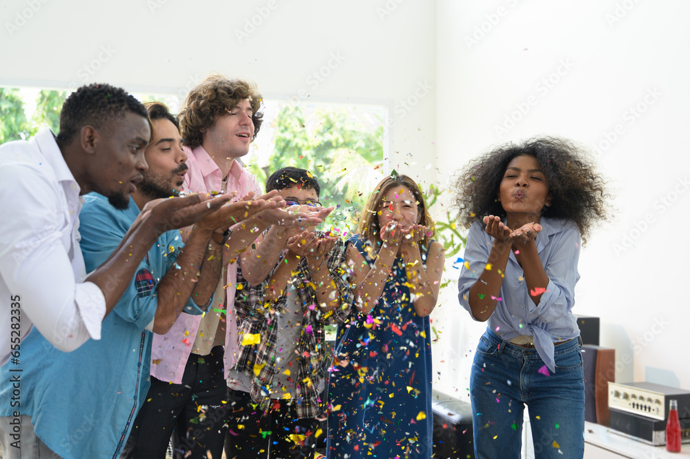 Group of six friends having fun at home blowing colorful confetti ...