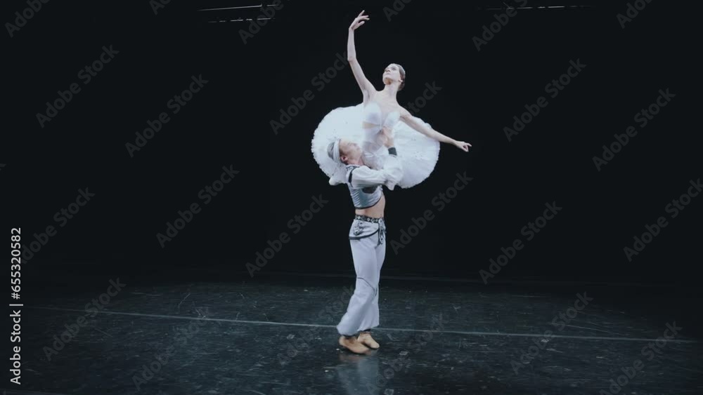 Ballet. Beautiful graceful pose. The partner holds the ballerina high ...