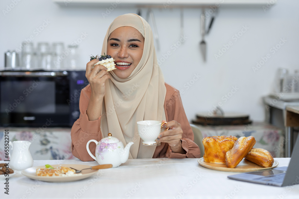 young muslim woman in hijab eating sweets, bread, waffles, cakes ...