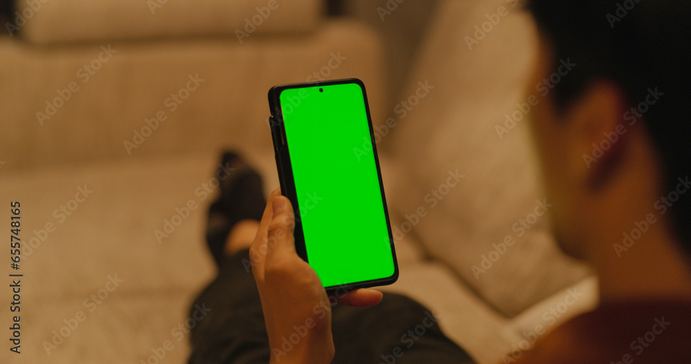 Foto de Over the Shoulder Footage of an Anonymous Male Relaxing at Home, Using Smartphone with ...