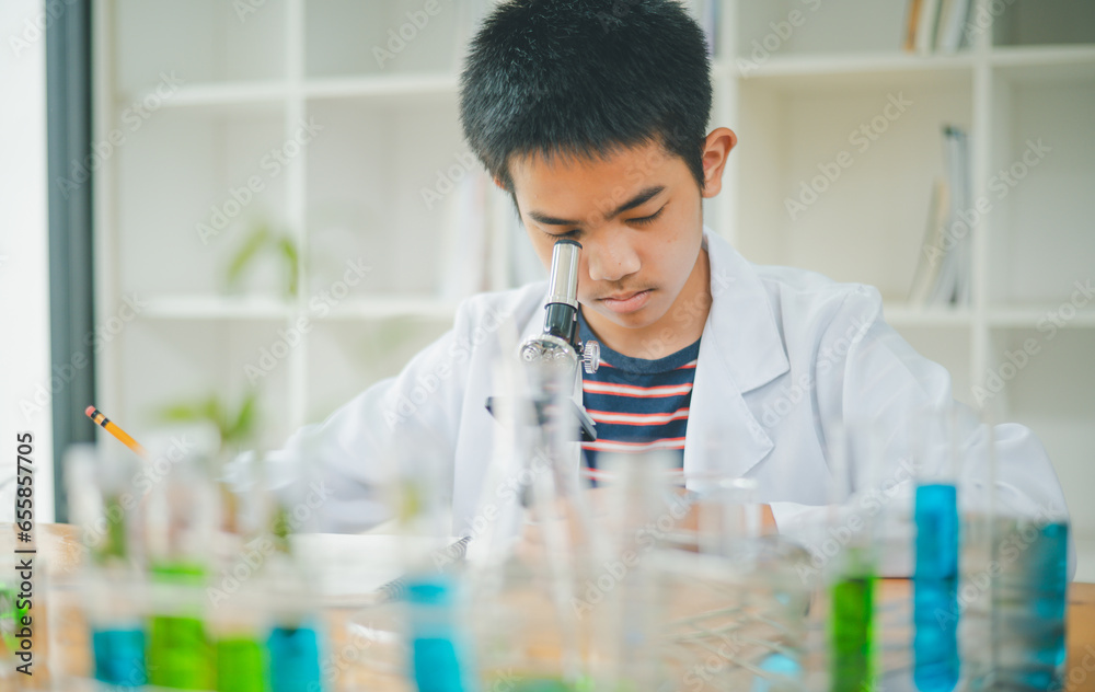 Asian male science students looking through a microscope and tests of ...